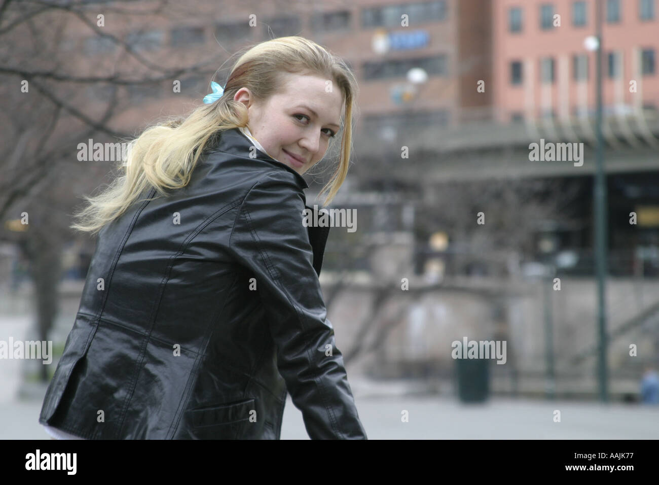 Young woman viewed from behind sitting in a park Stock Photo - Alamy