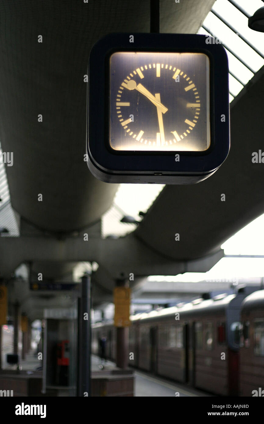 a time clock hangs in a train station Stock Photo - Alamy
