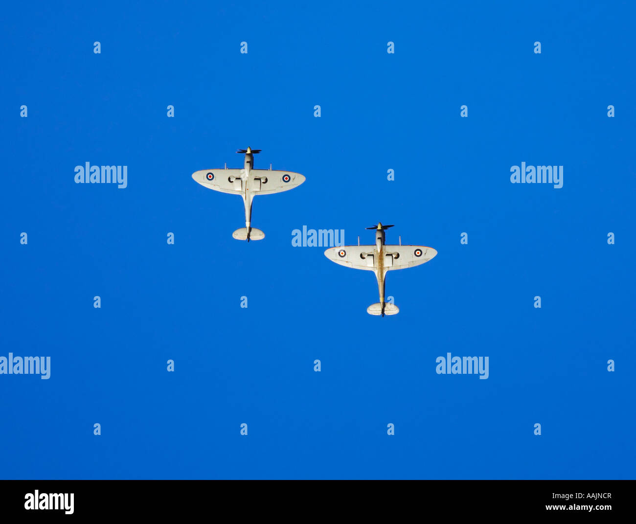 Two Spitfires flying over seen from below against a blue sky Stock ...