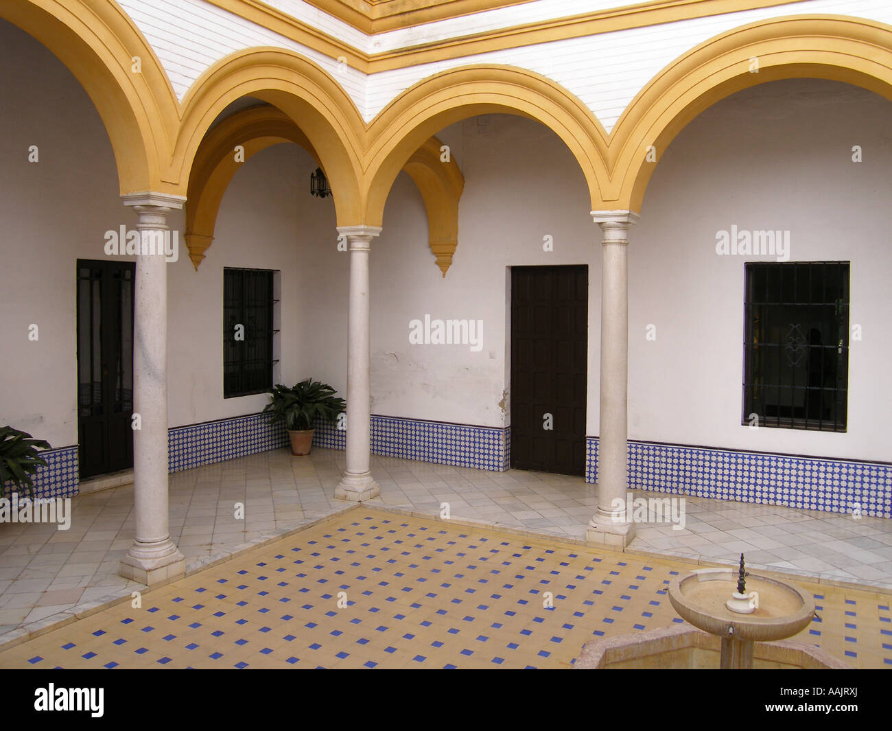 Inside Alcázar in Seville, Spain. View of the open colorful veranda and ...