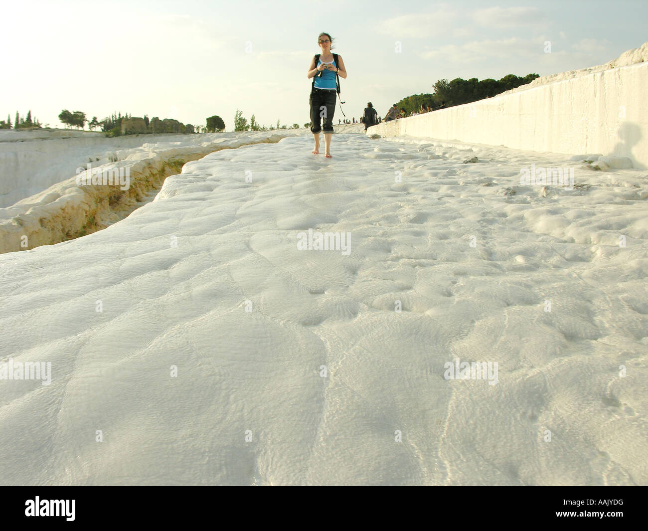 A backpacker walks on the natural calcium cliffs at Pamukkale Turkey ...