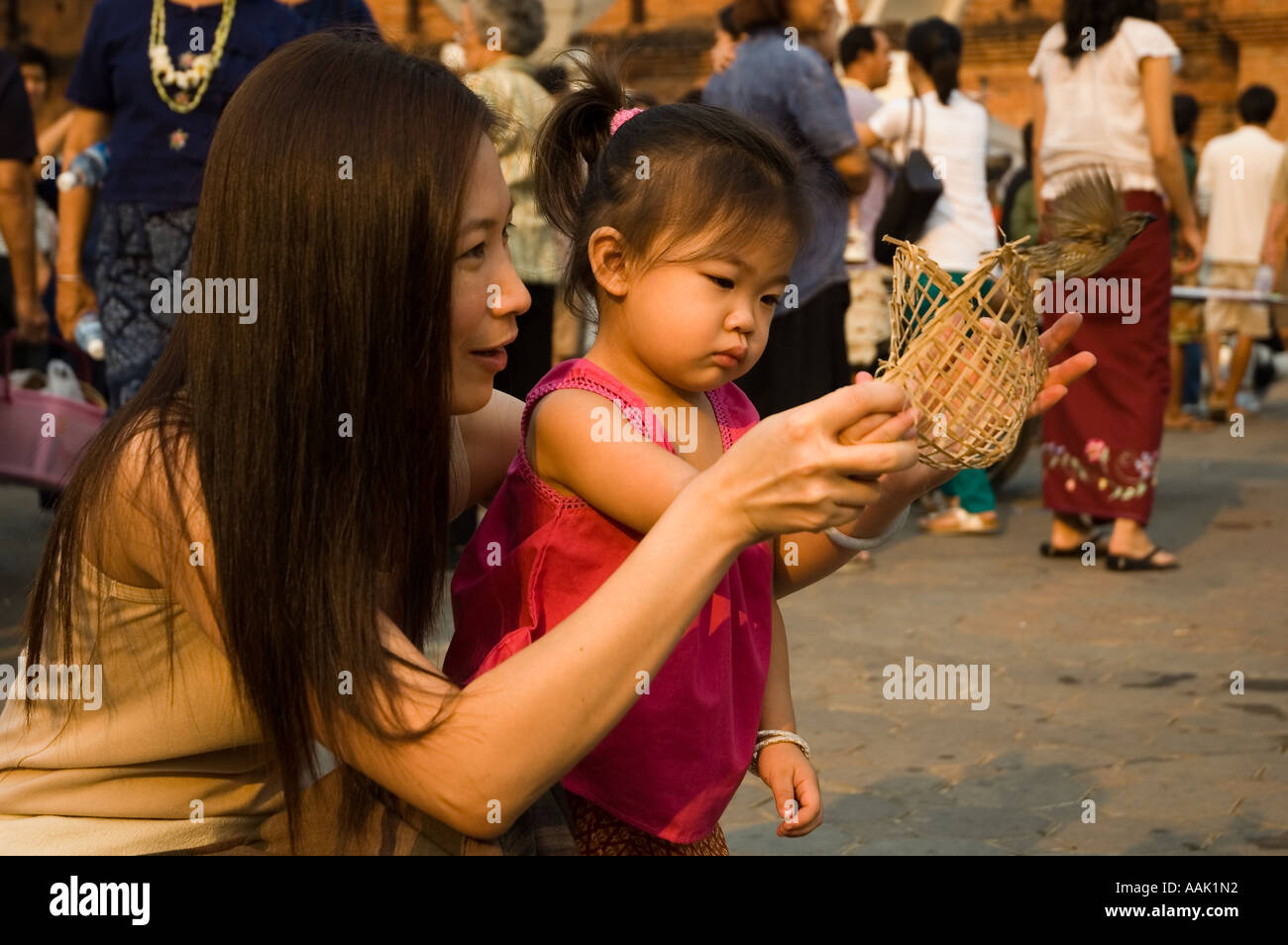A mother and daughter release birds from a cage to gain good luck in ...