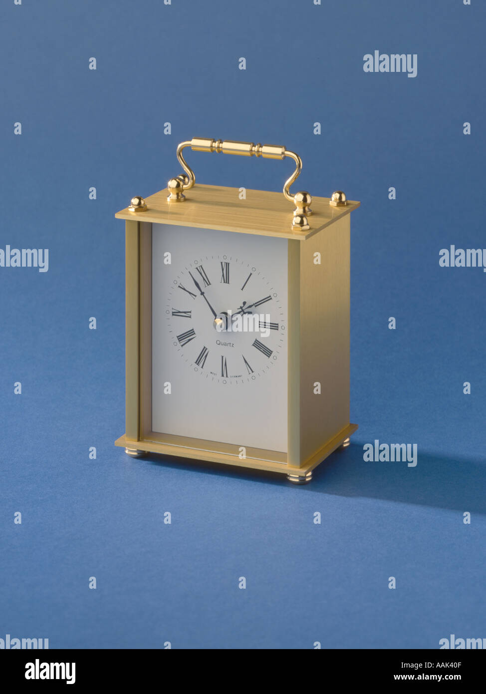 Brass carriage clock time instrument on blue background Stock Photo - Alamy