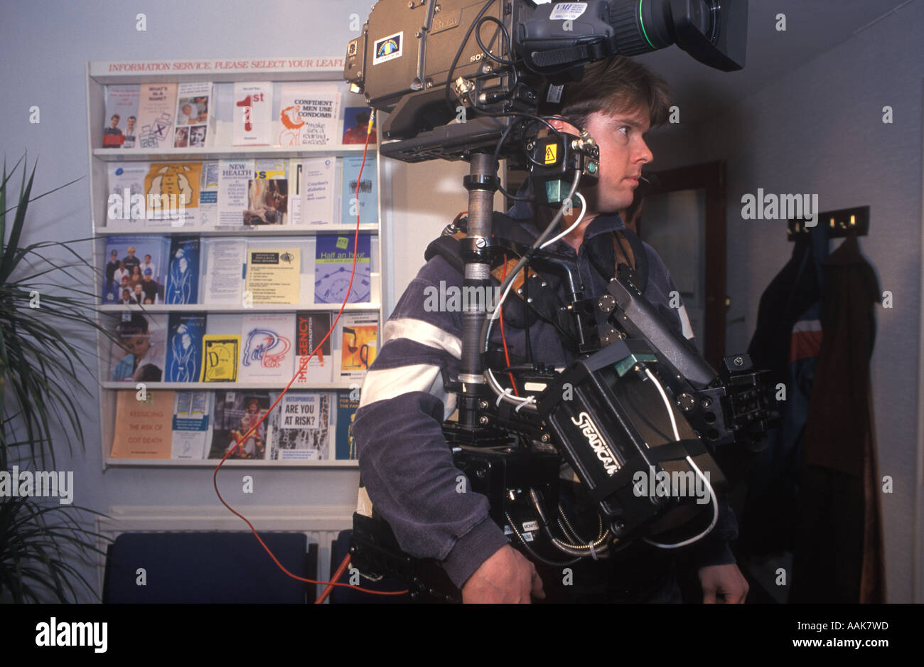 A television camera man with a stedicam camera waiting to start filming ...