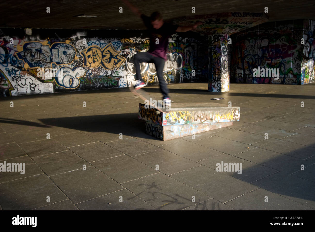 Skateboarder performing a stunt on his skateboard Stock Photo - Alamy