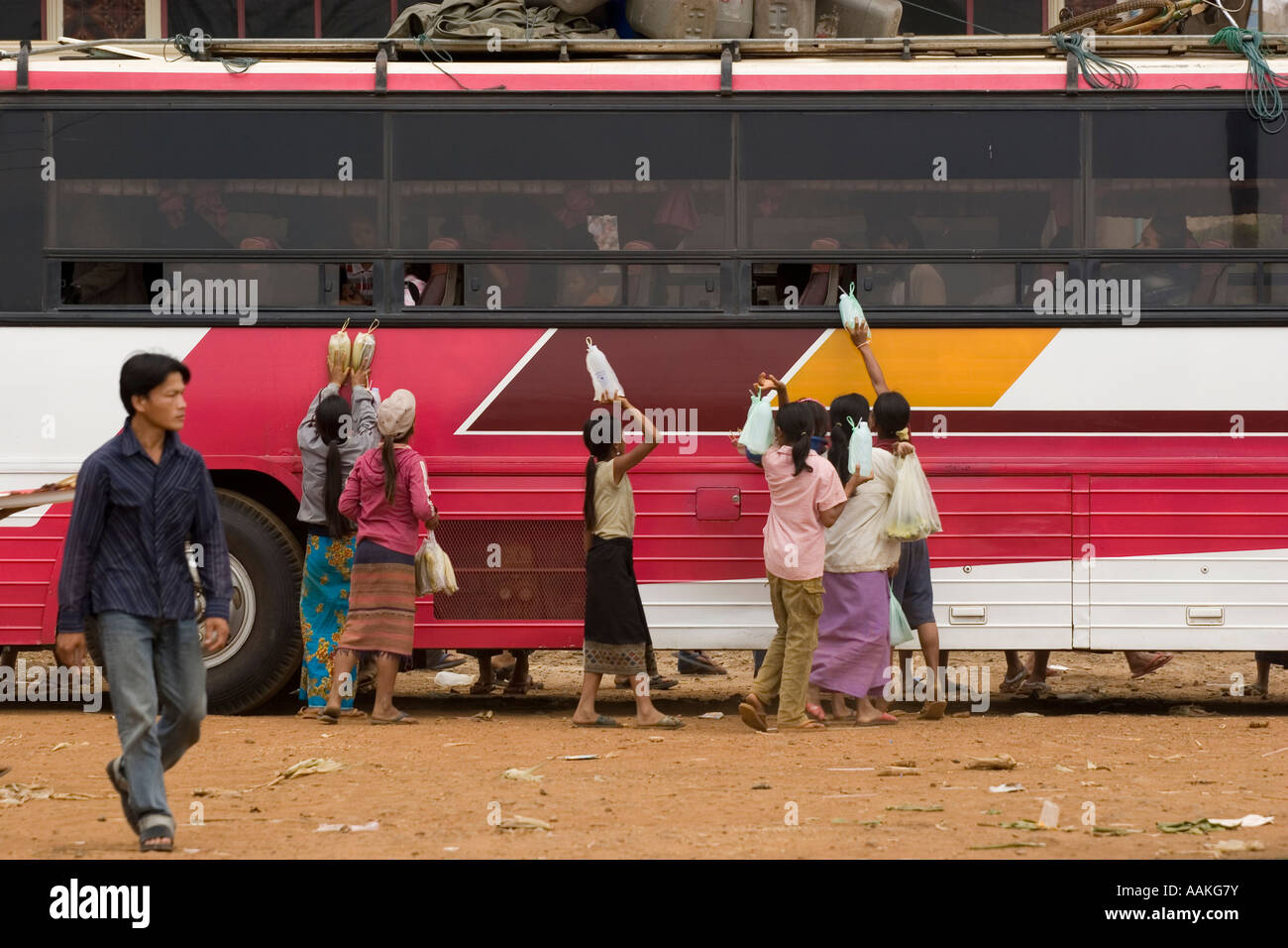 Vendors trying to sell items to bus passengers at the bus station in ...