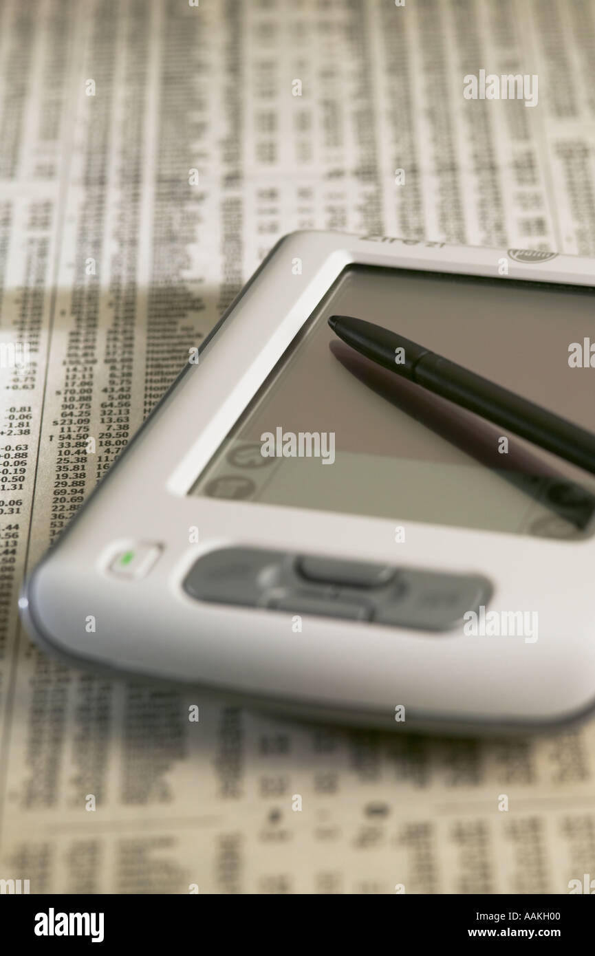 Handheld computer on newspaper Stock Photo - Alamy