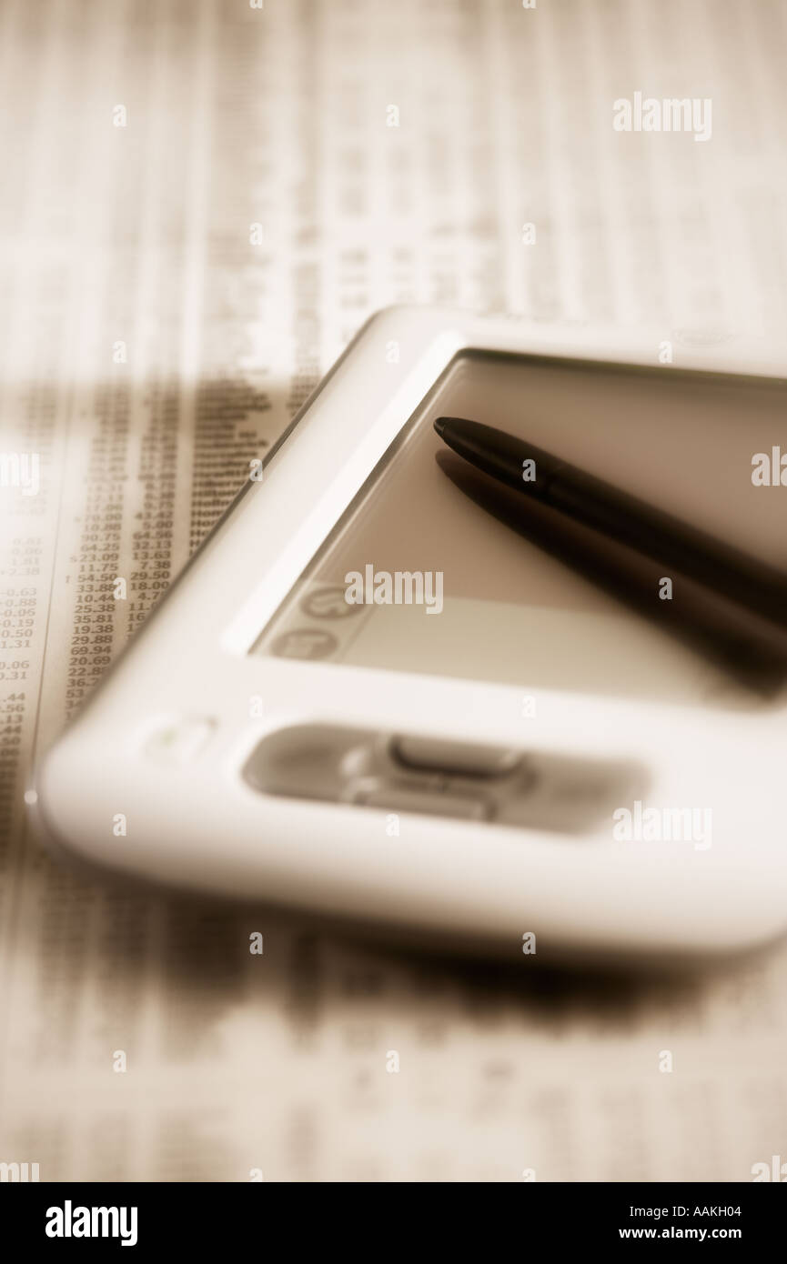 Handheld computer on newspaper Stock Photo - Alamy