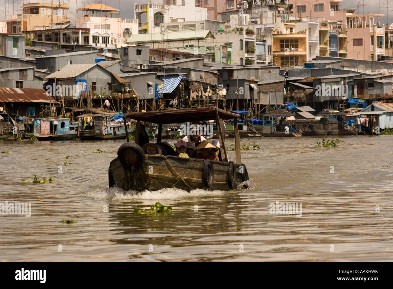 Boat in the Mekong delta with the city of Chau Doc behind it, Vietnam ...