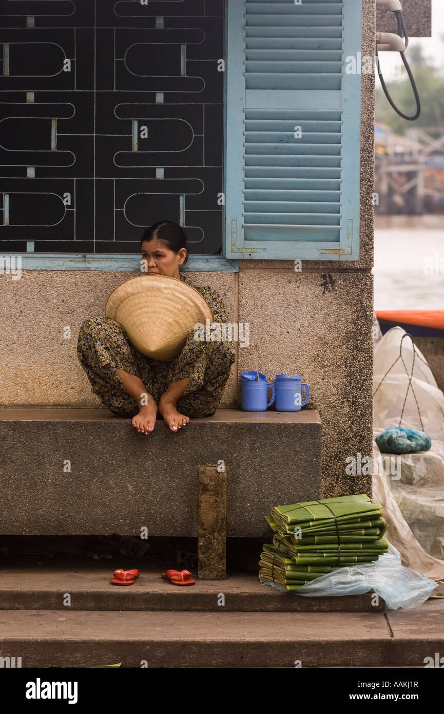 Woman with hat sits by the street in Ben Tre Vietnam Stock Photo - Alamy