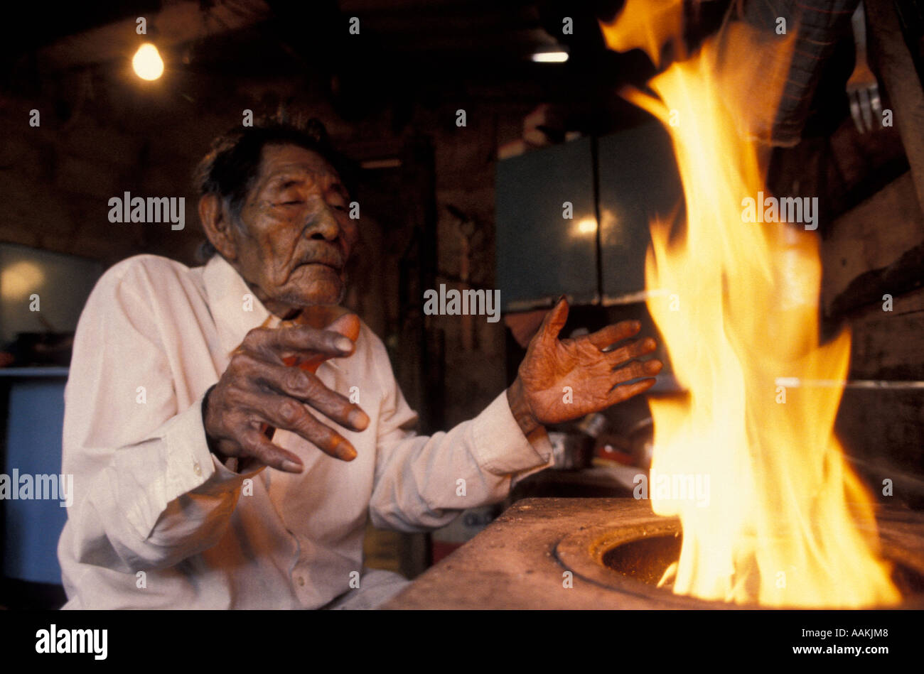 Guató indigenous people, elderly native man warms his hands at the ...