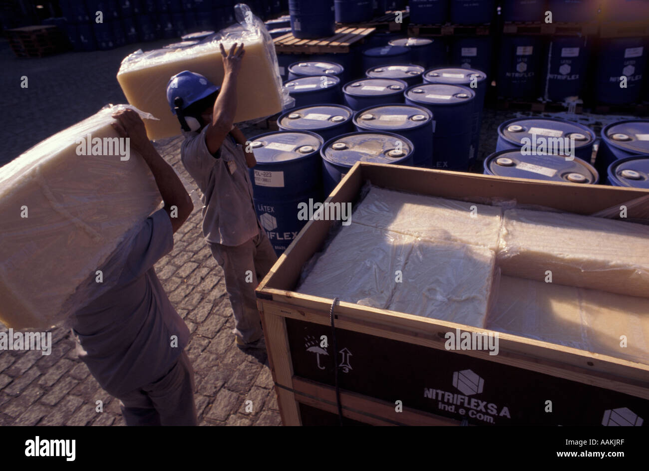 Nitrilic rubber production. Industry, workers load rubber into boxes ...