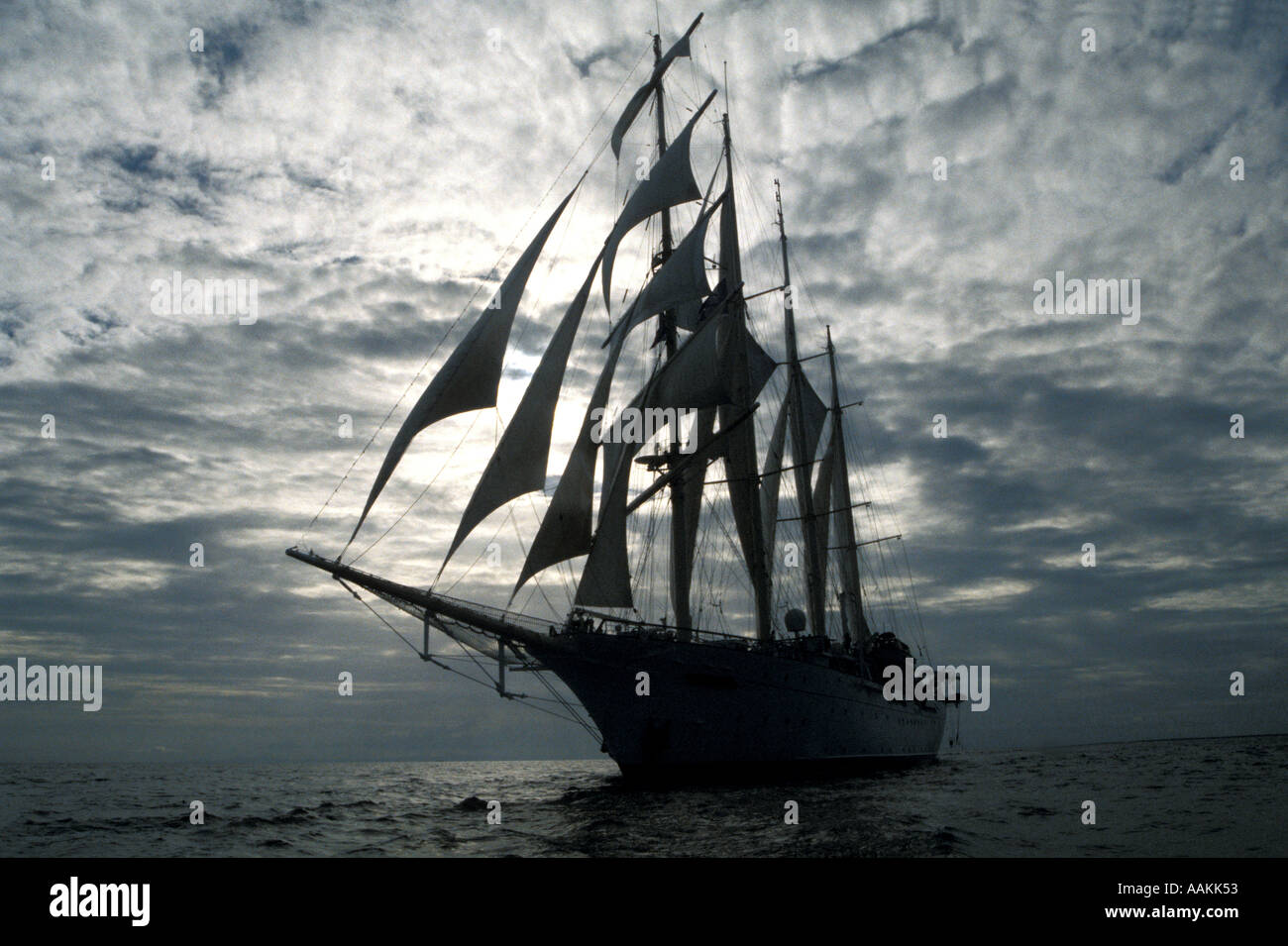 Cruising tall sailing ship in silloutte with clouds Stock Photo - Alamy