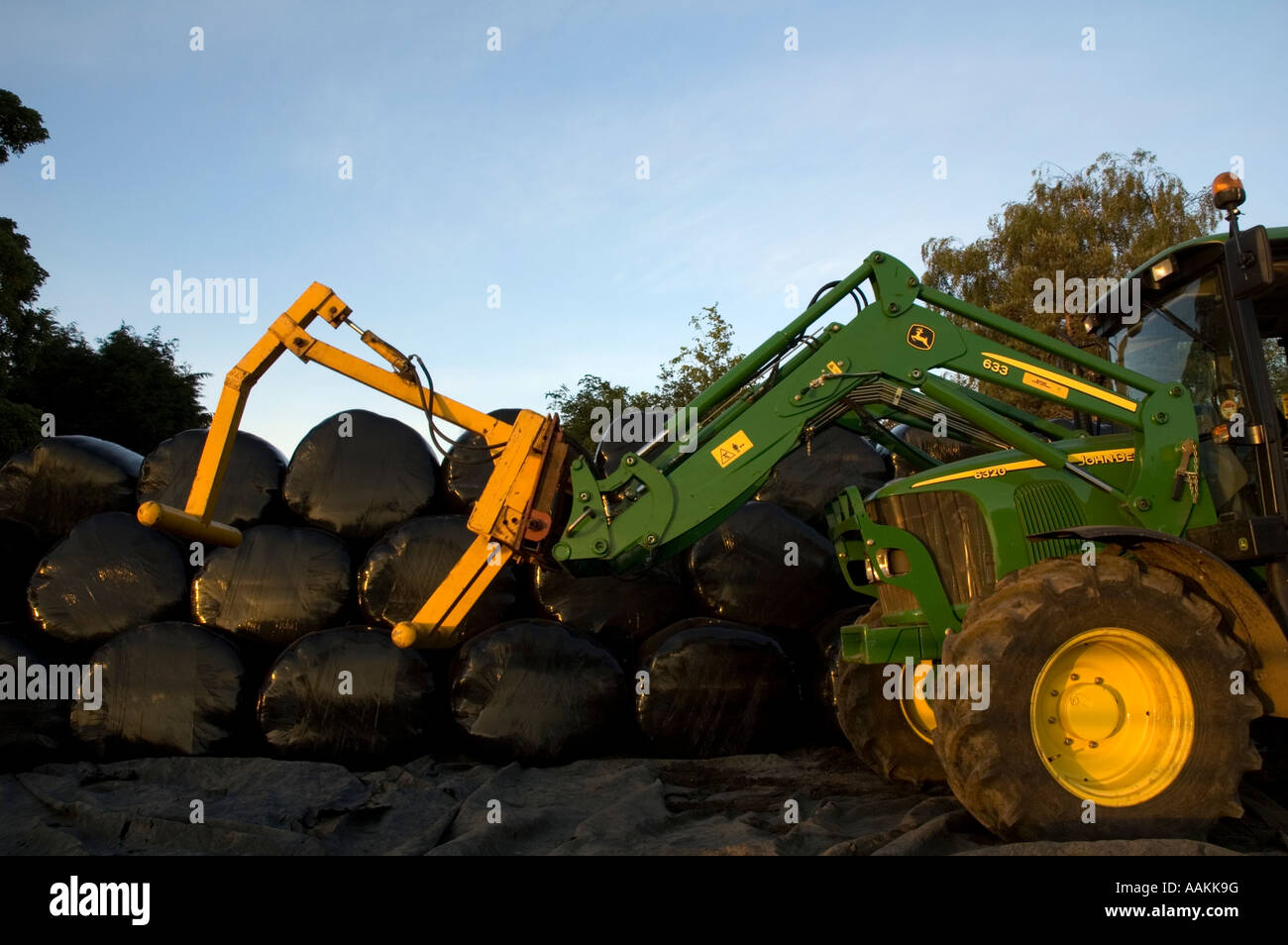 John Deere 6320 Loader tractor and wrapped silage bales, North ...