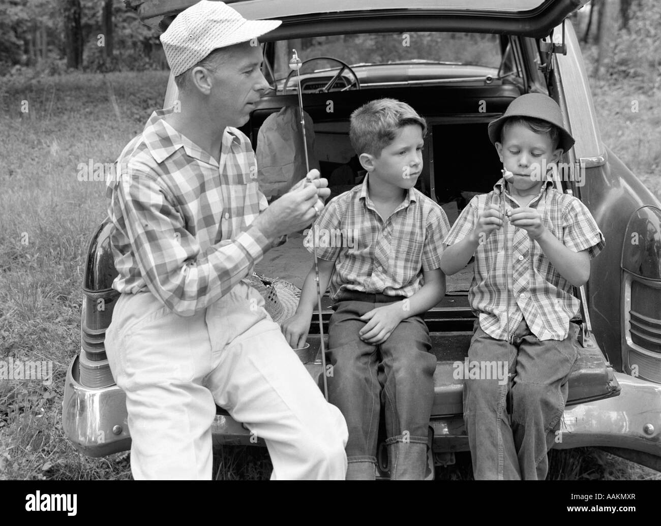 1950s 1960s FATHER TWO YOUNG SONS WITH FISHING RODS BY CAR OUTDOOR ...