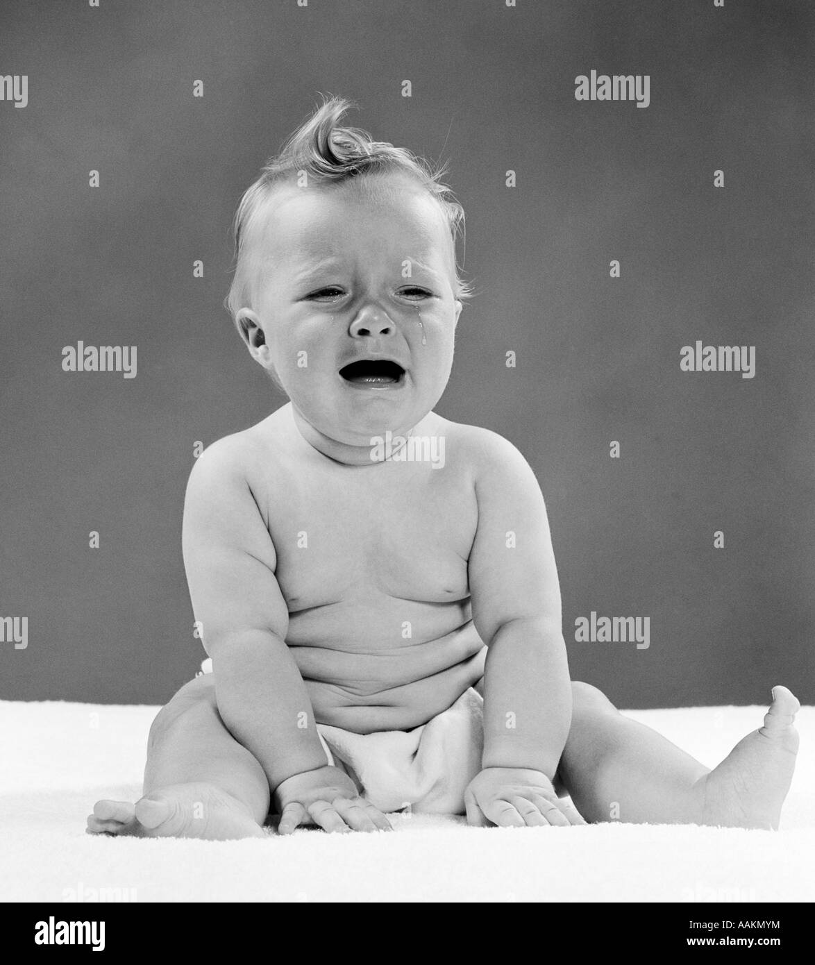 1950s CRYING BABY SEATED WITH DISTRESSED EXPRESSION & TEARS STREAMING ...