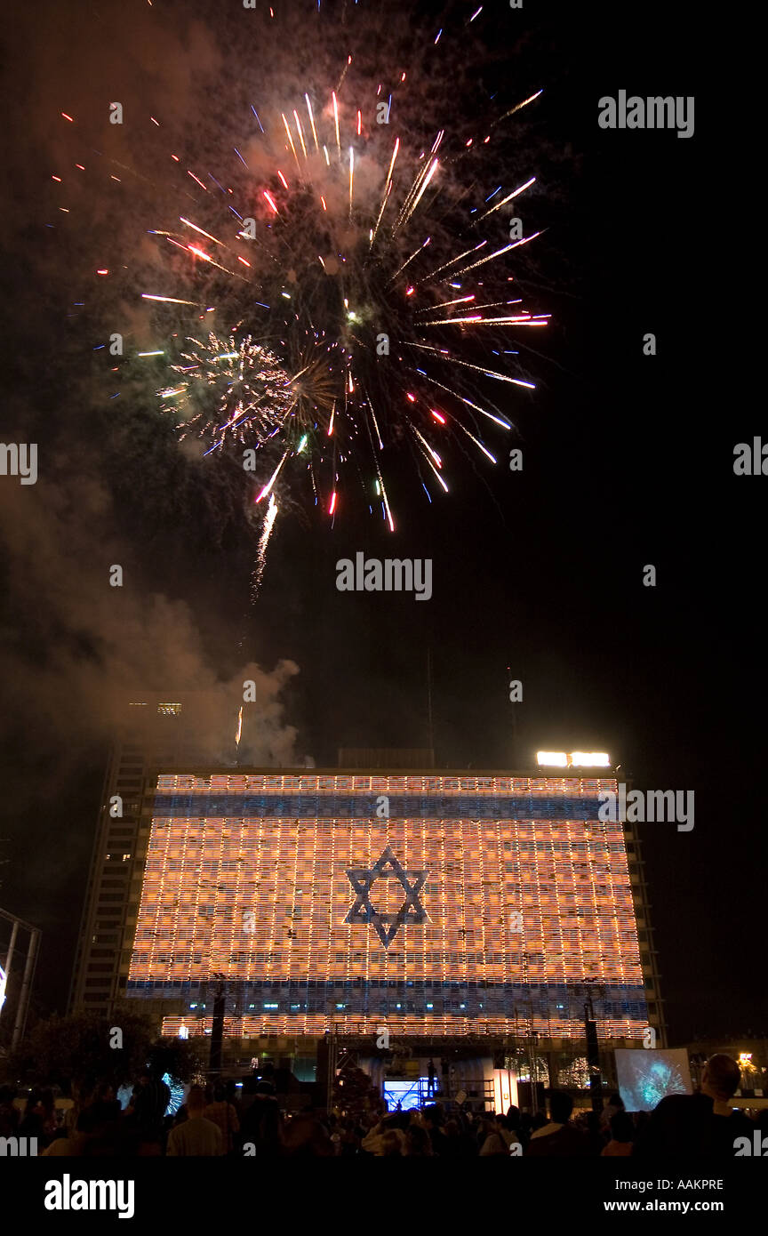 Fireworks light the sky over the illuminated city hall building bearing ...