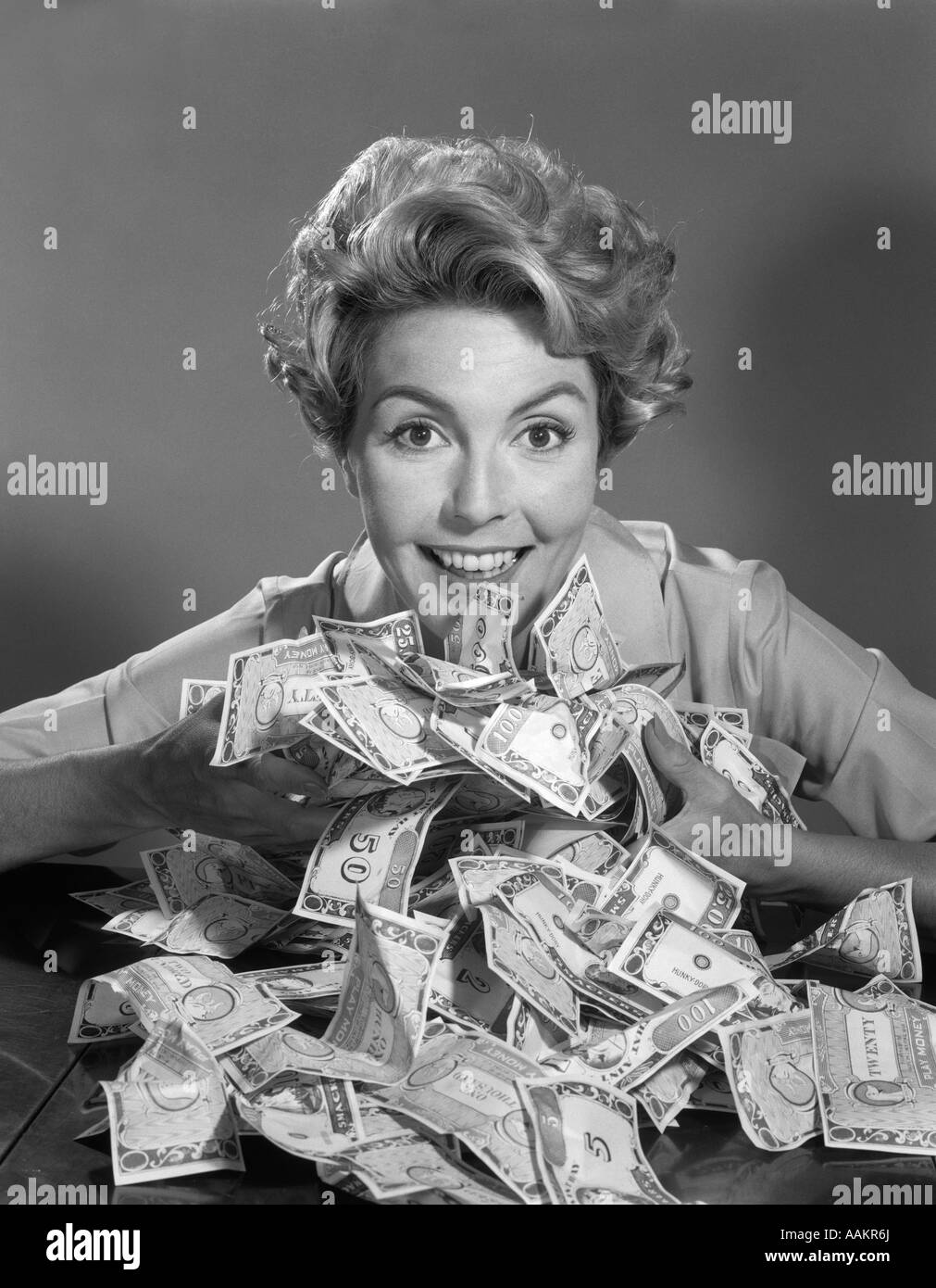 1950s 1960s SMILING WOMAN SCOOPING UP PILE OF MONEY BILLS CASH LOOKING ...
