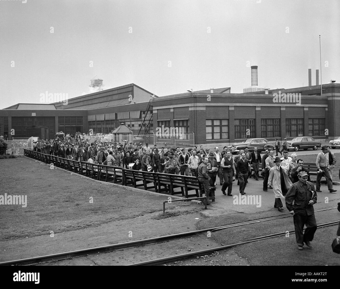 1950s MASS OF FACTORY WORKERS LEAVING BUILDING AFTER WORK Stock Photo ...