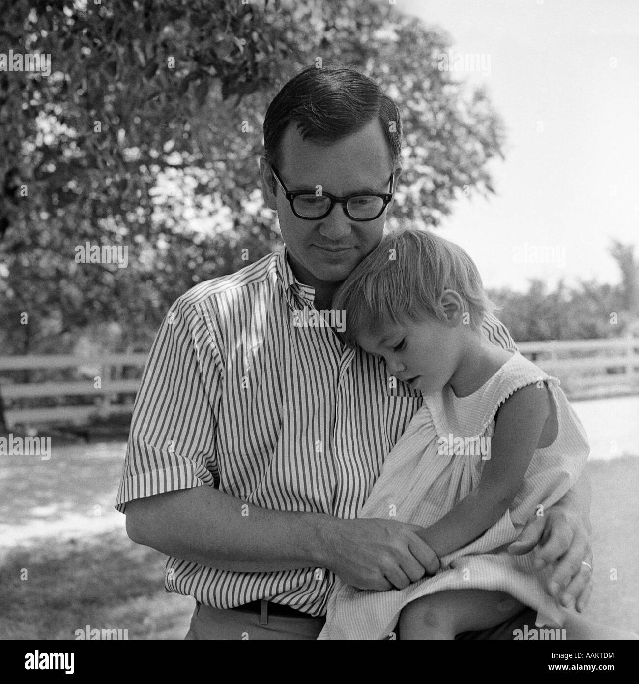 1970s FATHER SITTING OUTSIDE WITH DAUGHTER ON KNEE COMFORTING HER Stock ...