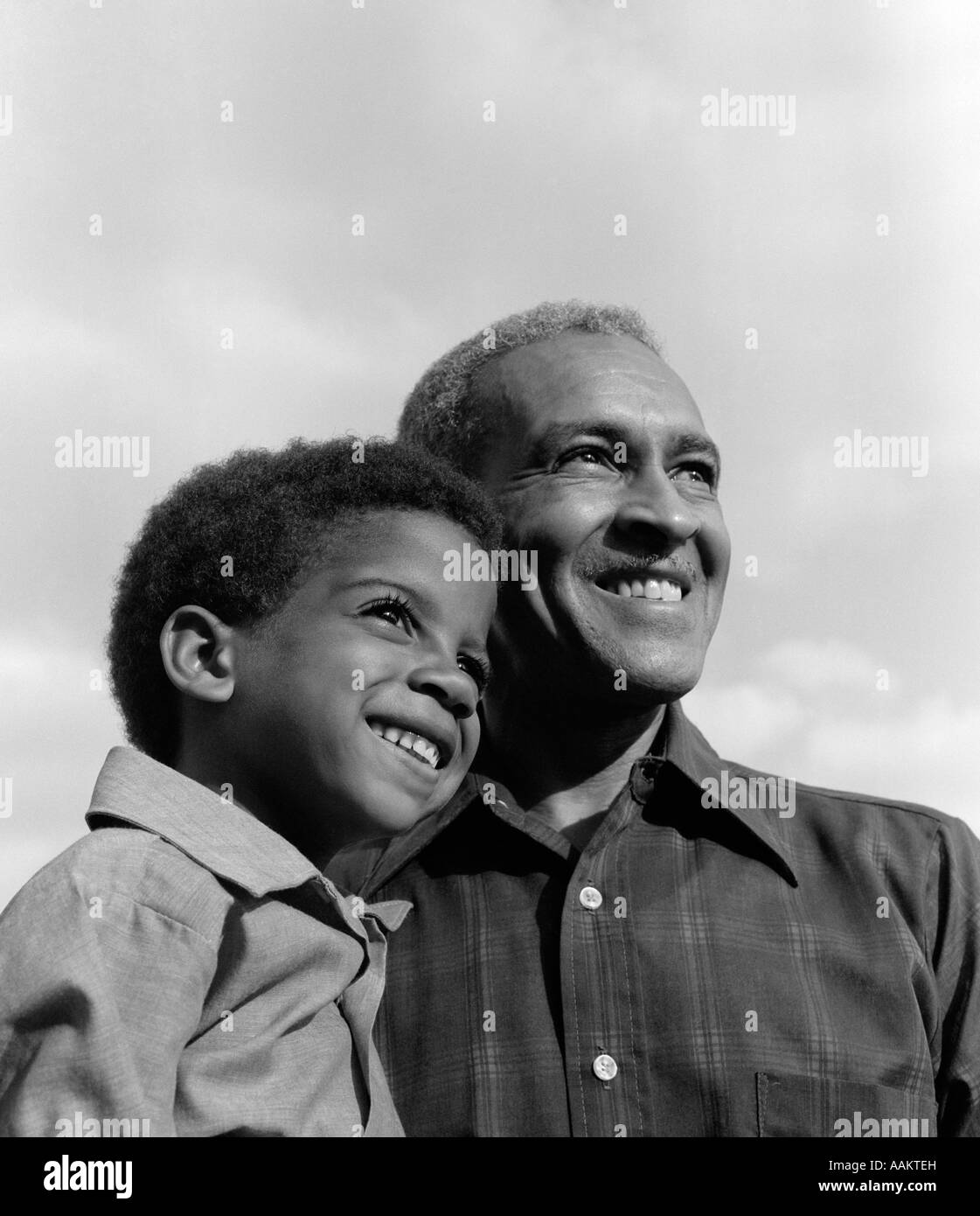 1970s SMILING BLACK BOY & GRANDFATHER WITH ARMS AROUND EACH OTHER ...