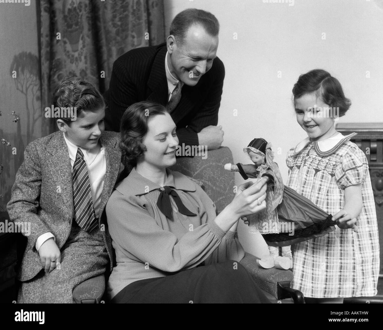 1930s FAMILY OF FOUR GATHERED AROUND LOOKING AT DAUGHTER'S DUTCH GIRL ...