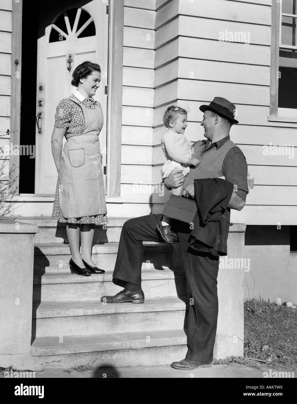 1940s FATHER ON STEPS HOLDING DAUGHTER WITH MOTHER WATCHING Stock Photo ...