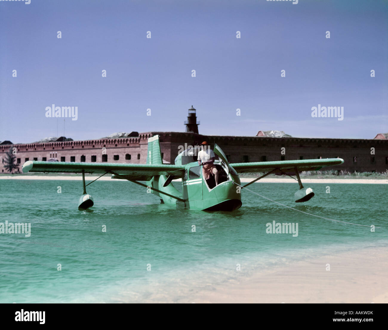 1950s MAN FISHING OFF FRONT OF SEAPLANE HYDROPLANE TURQUOISE BLUE GREEN ...