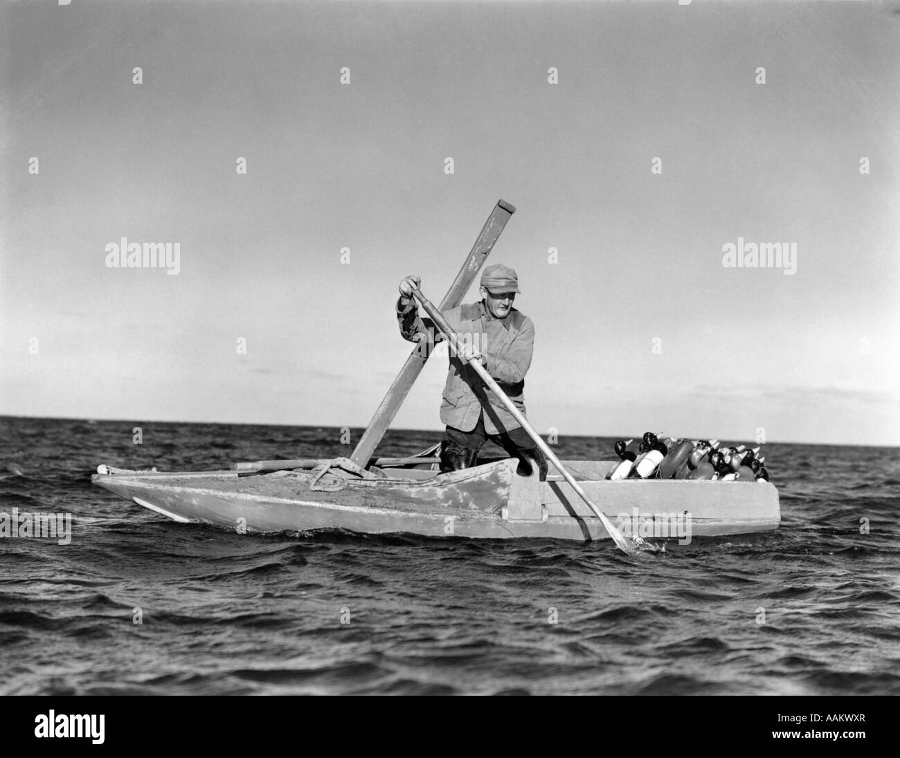 1930s 1940s MAN DUCK SHOOTING DEPLOYING DECOYS FROM SMALL BOAT Stock ...