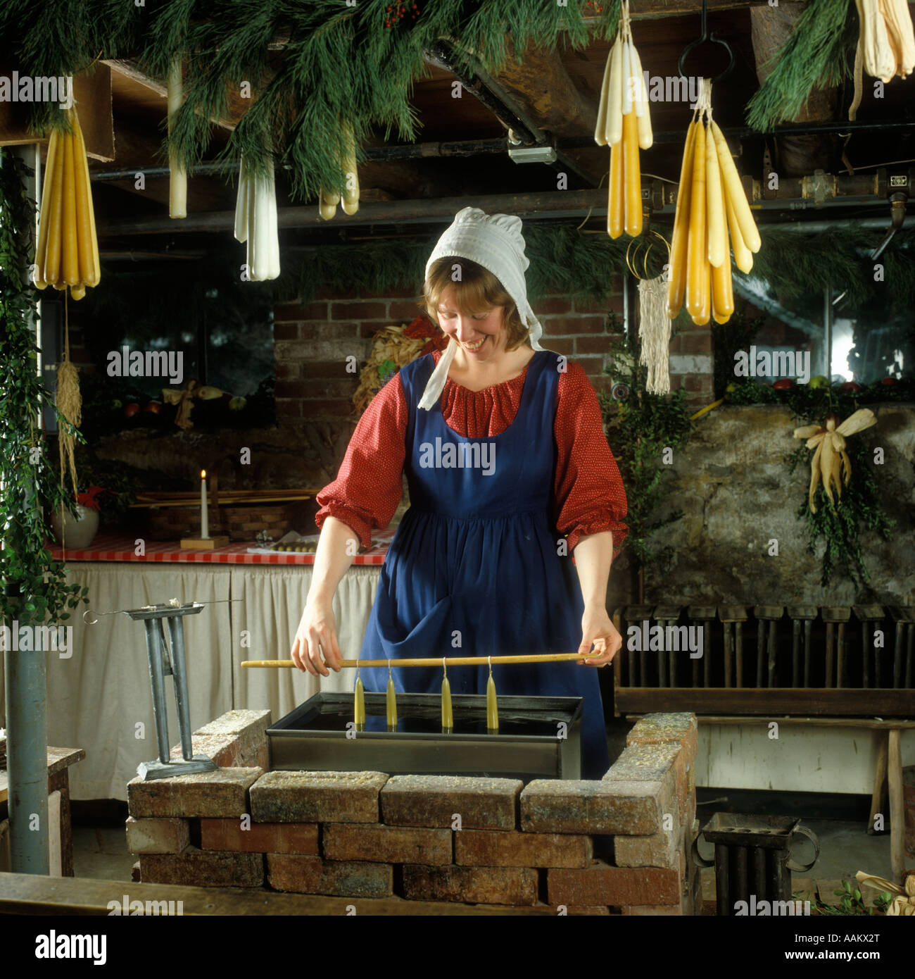1980s COLONIAL REENACTMENT WOMAN MAKING HAND DIPPED CANDLES Stock Photo ...