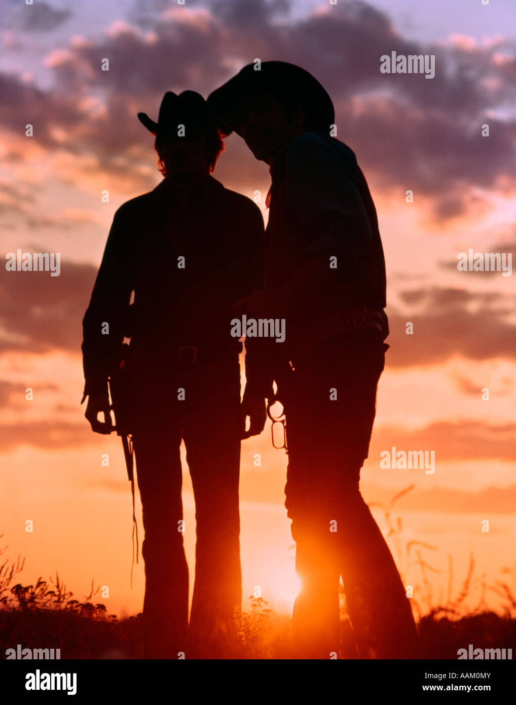 ORANGE SUNSET COWBOYS SILHOUETTE WEST Stock Photo - Alamy