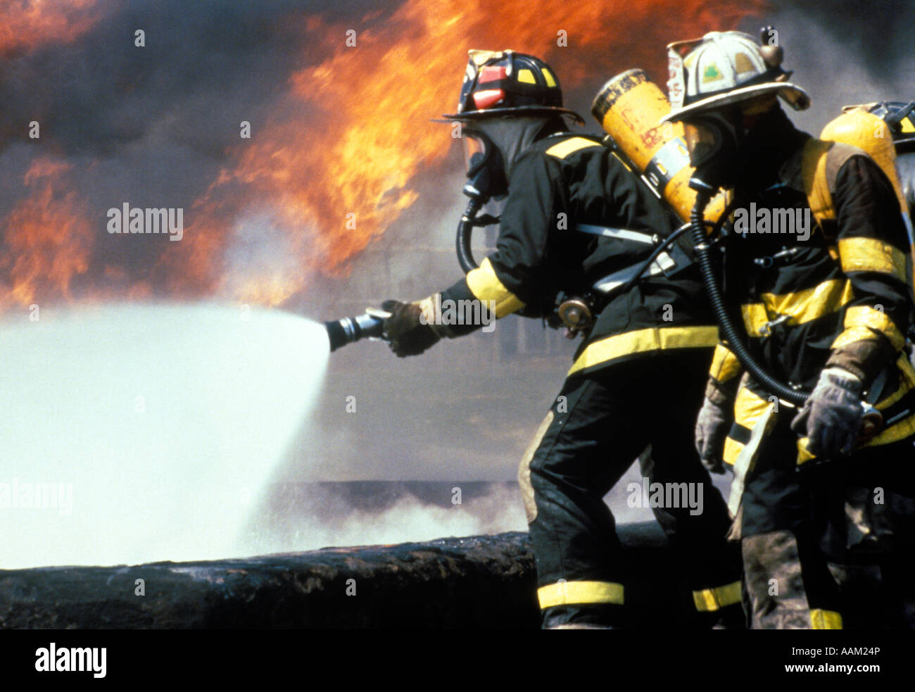 1990s FIREFIGHTERS WITH HOSE PUTTING OUT FIRE Stock Photo - Alamy