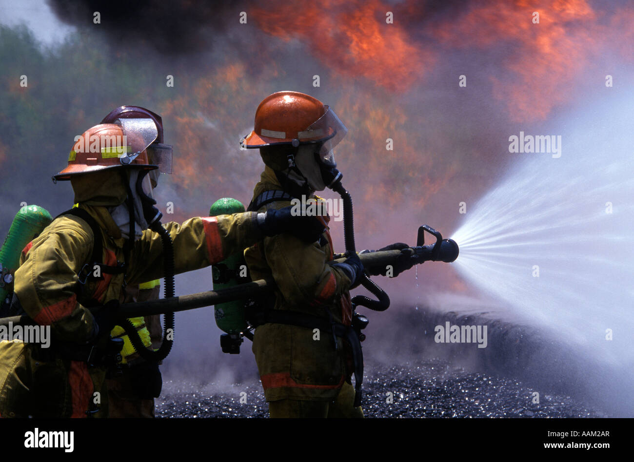TWO FIREFIGHTERS SPRAYING FIRE WITH WATER FROM HOSE Stock Photo - Alamy