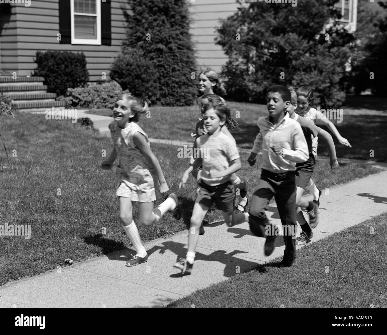 1970s GROUP OF KIDS RUNNING DOWN SUBURBAN SIDEWALK Stock Photo - Alamy