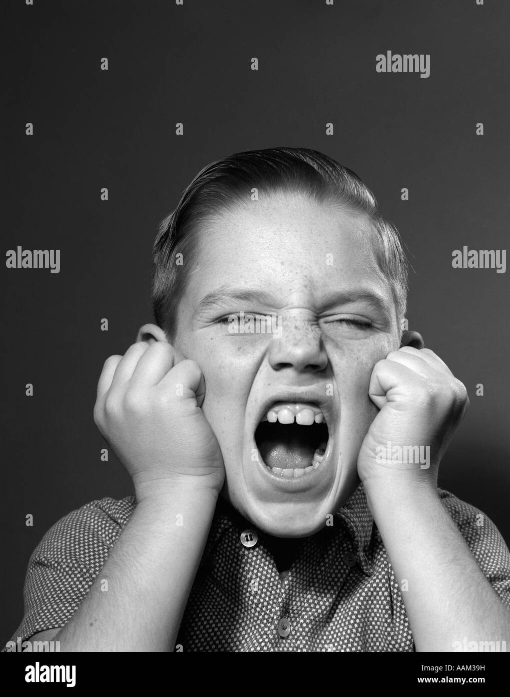 1950s PORTRAIT SCREAMING BOY MOUTH WIDE OPEN ANGRY CLINCHED FISTS Stock ...