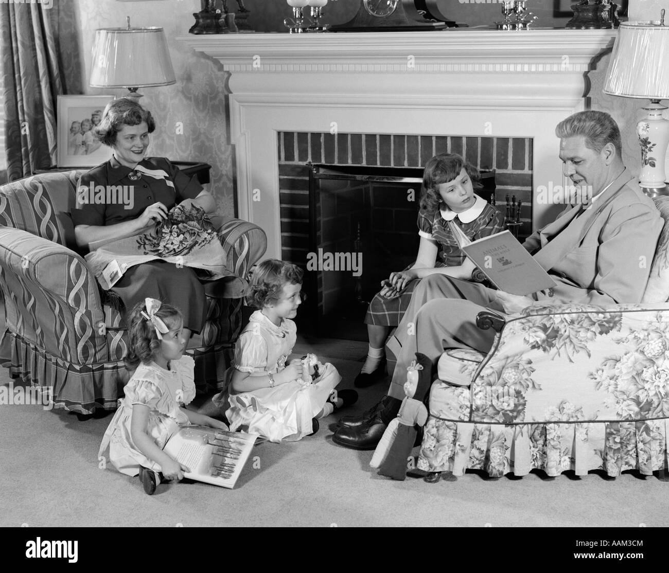 1950s FAMILY OF FIVE MOTHER FATHER AND THREE GIRLS SITTING IN FRONT OF ...