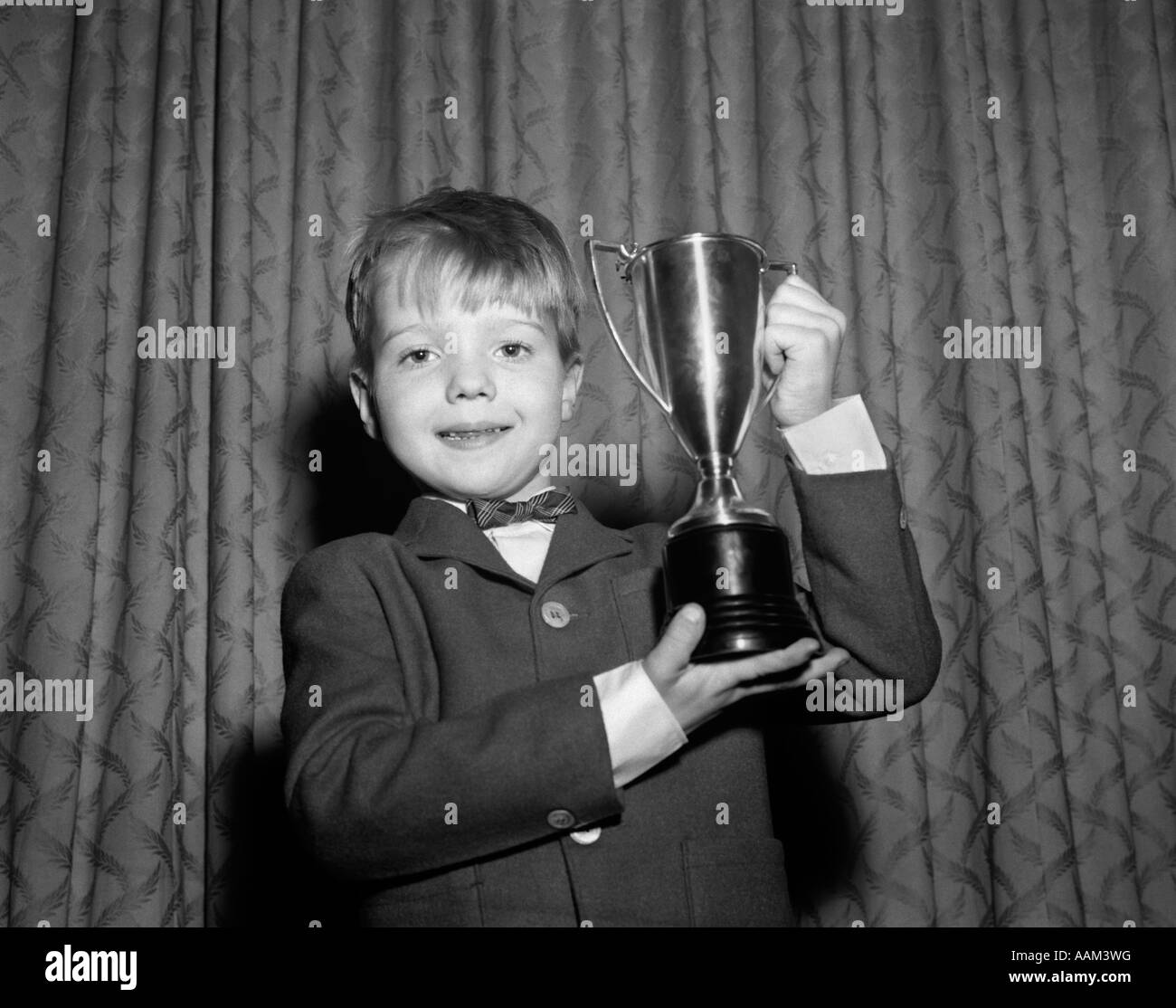 1950s SMILING PROUD BOY HOLDING UP TROPHY AWARD Stock Photo - Alamy