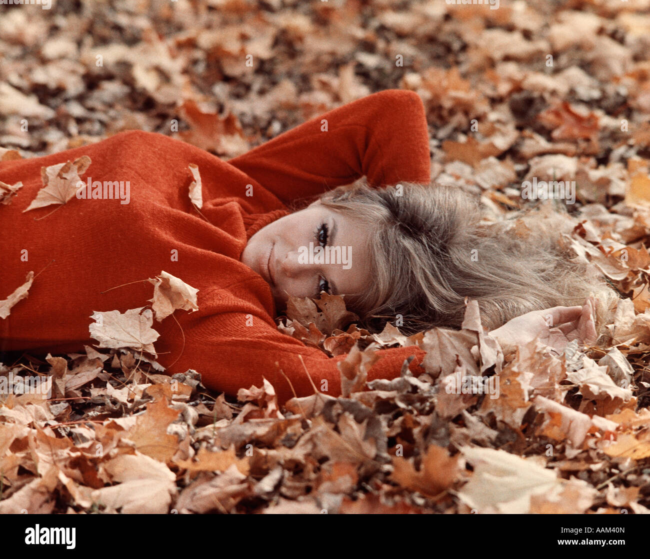 1970s PORTRAIT BLOND WOMAN SMILING LAYING AUTUMN TREE LEAVES Stock ...