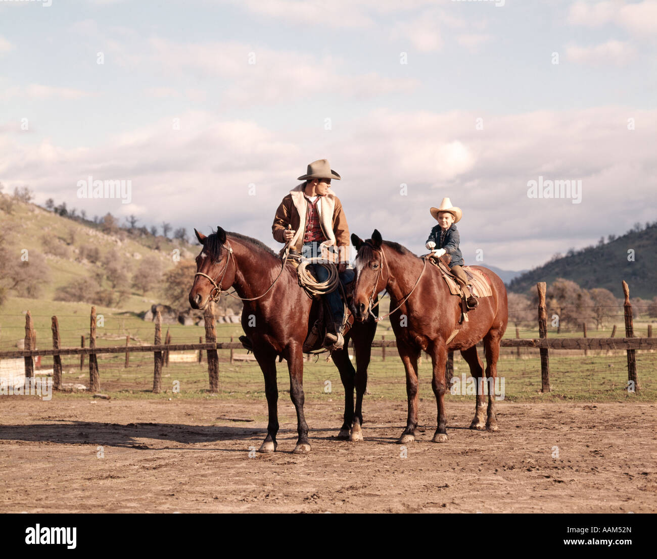 1970s MAN COWBOY FATHER AND BOY SON SITTING TOGETHER ON HORSES BY ...