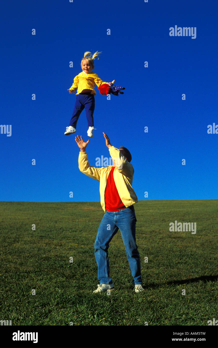 FATHER TOSSING DAUGHTER UP IN THE AIR Stock Photo - Alamy