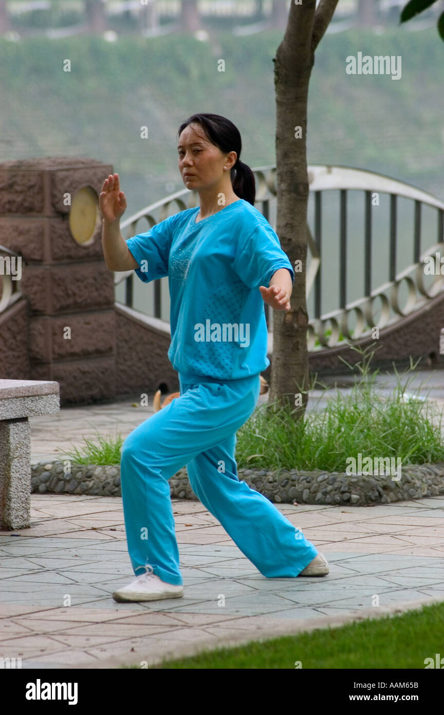 Chinese woman practices Tai Chi in a city park along the Jin River ...