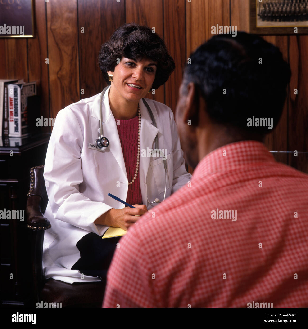 1980s FEMALE DOCTOR INTERVIEWING AFRICAN AMERICAN MALE PATIENT Stock ...