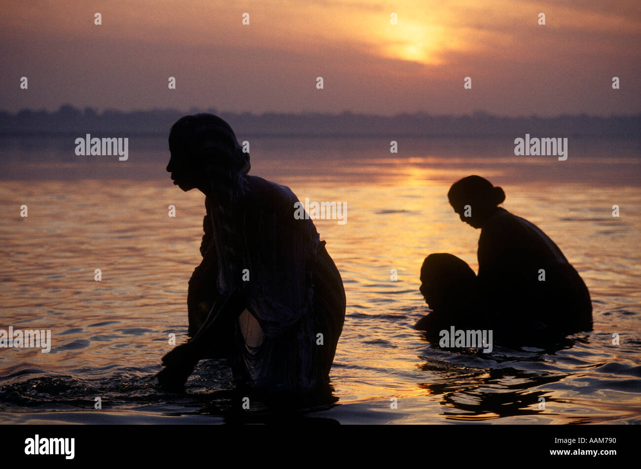 Faithful HINDU WOMEN bathe and perform ablutions in the GANGES RIVER at ...