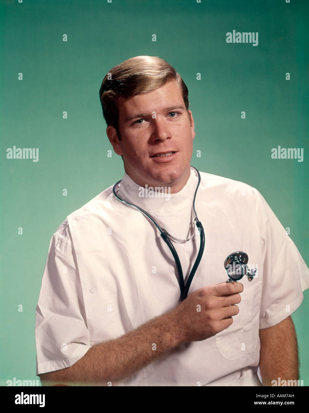 1960s PORTRAIT OF YOUNG DOCTOR HOLDING STETHOSCOPE LOOKING AT CAMERA ...