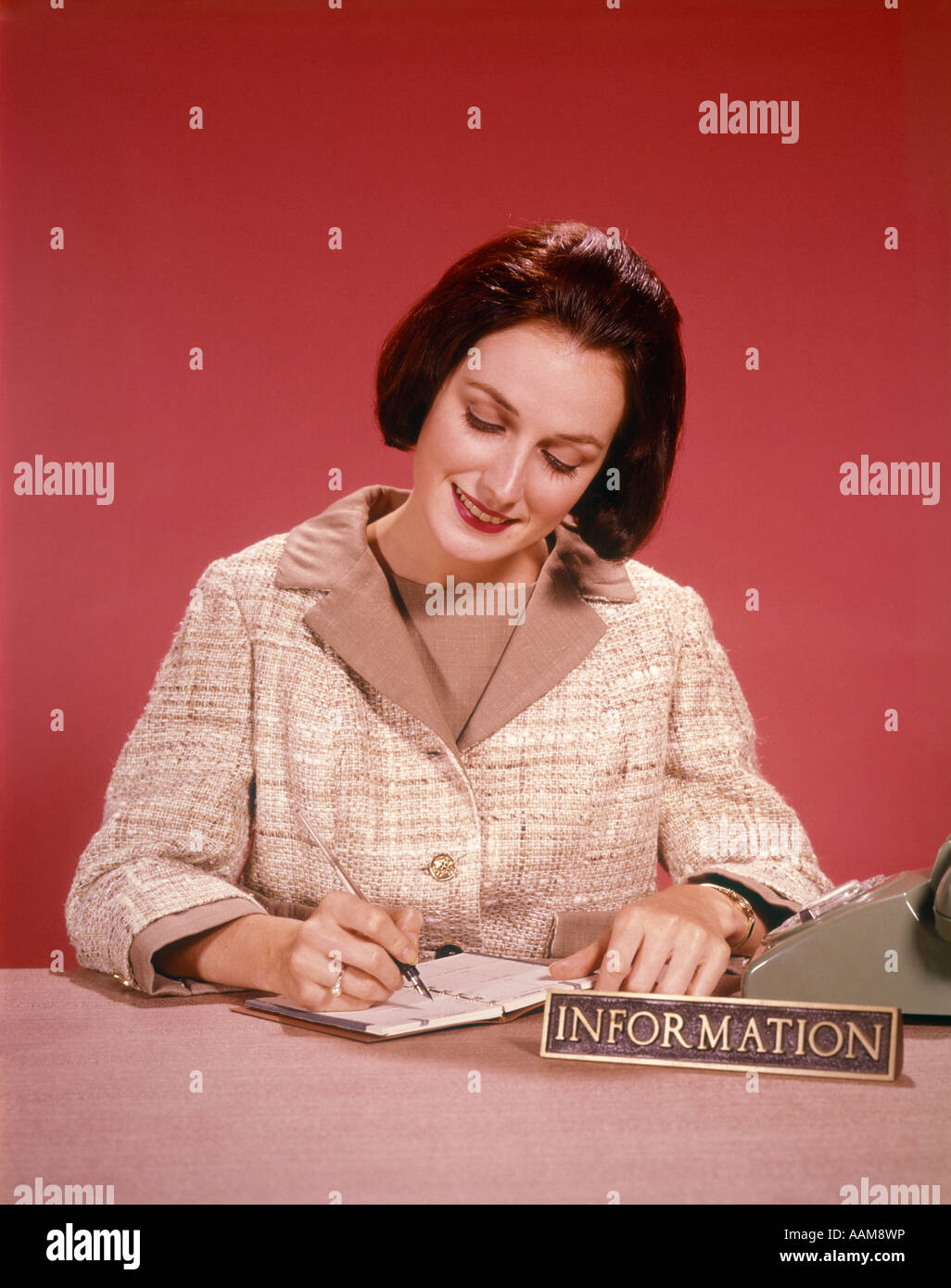 1960s SMILING WOMAN WRITING IN NOTE BOOK BESIDE TELEPHONE AT ...