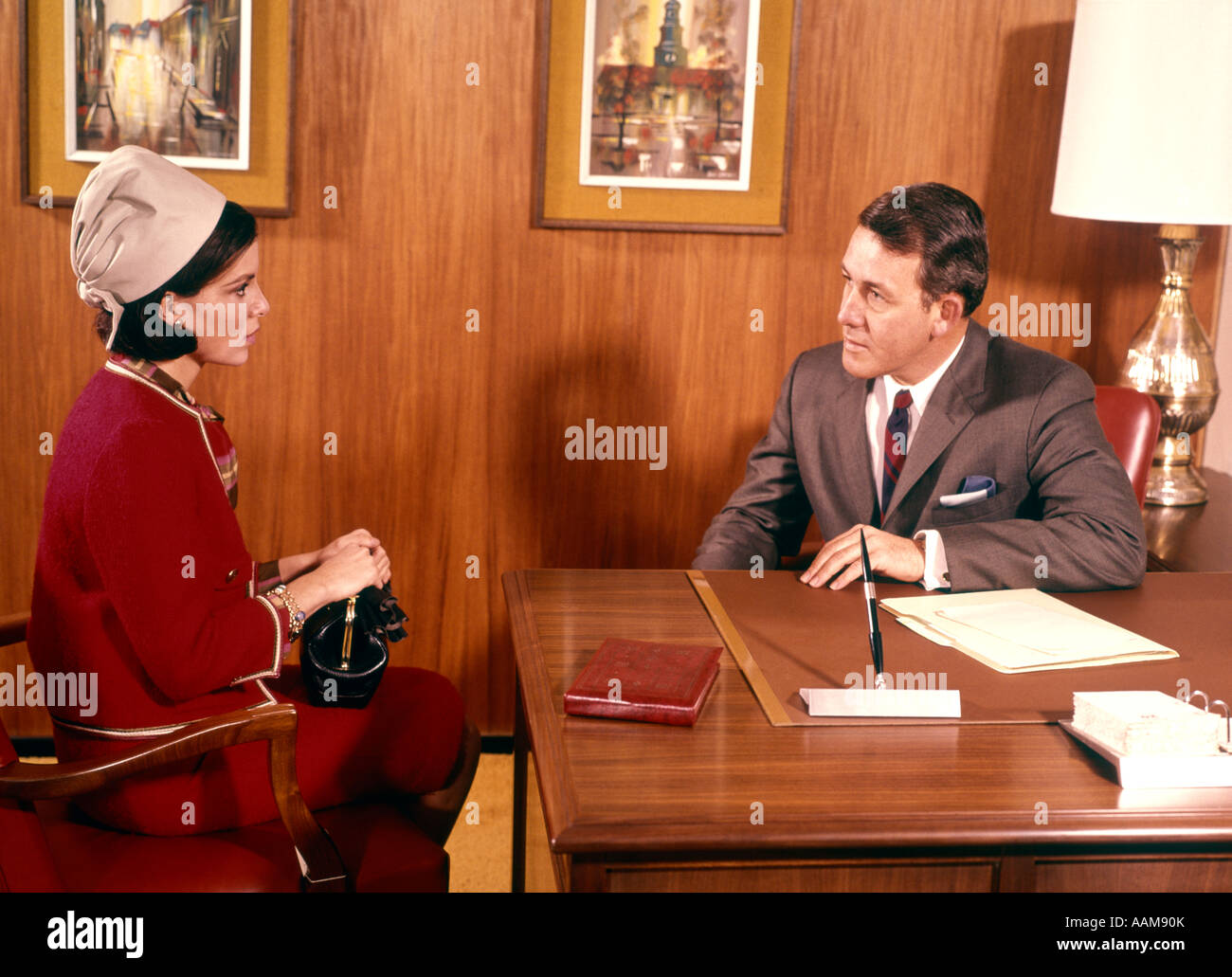 MAN INTERVIEWING WOMAN AT DESK IN OFFICE INDOOR BUSINESS INTERVIEW ...