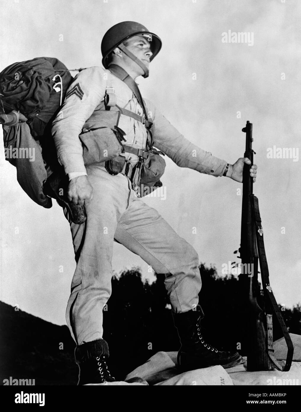 1940s SERGEANT IN ARMY UNIFORM IN PROFILE POSING WITH RIFLE HELMET ...