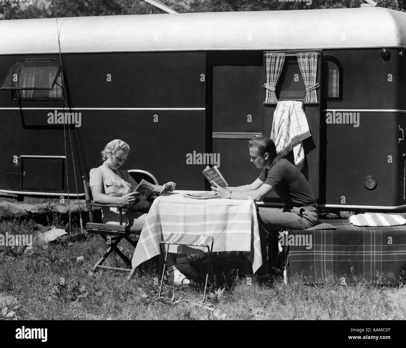 1940s COUPLE MAN WOMAN TRIP CAMPING TRAILER READING TABLE LUNCH Stock ...