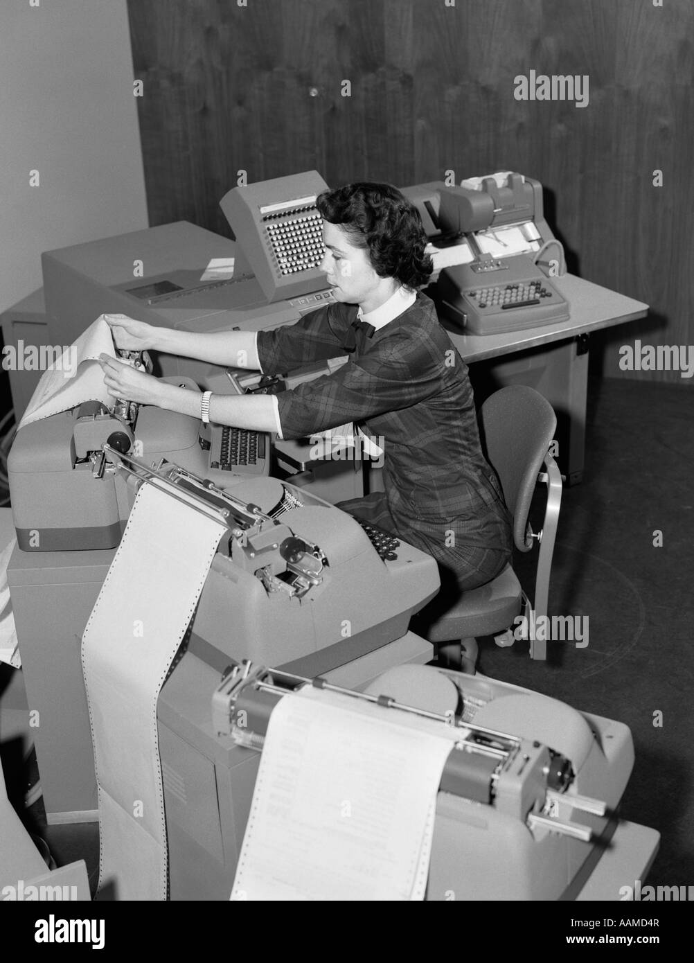 1950s WOMAN AT WORK STATION SURROUNDED BY ACCOUNTING MACHINES SPEWING ...