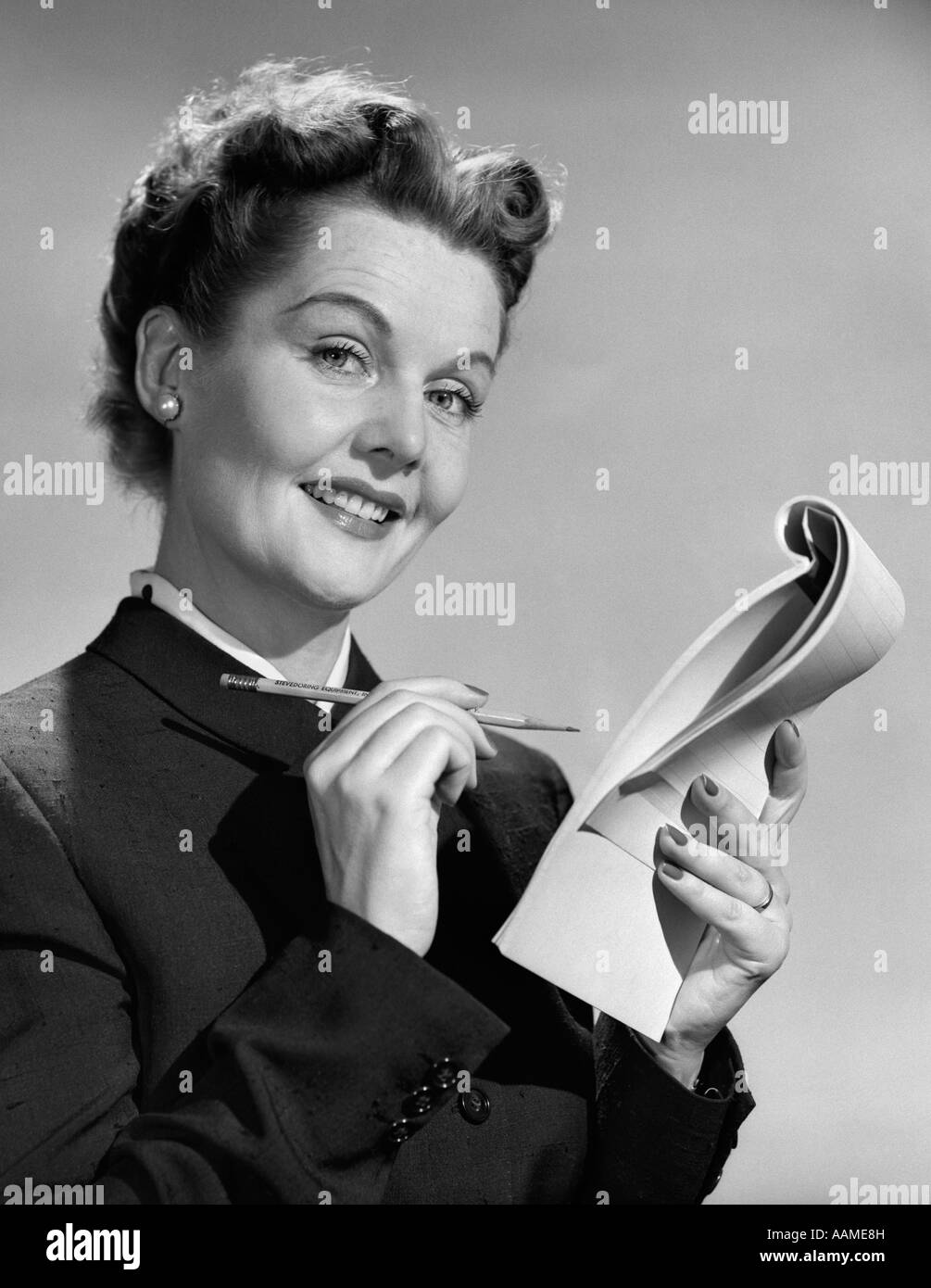 1950s SMILING WOMAN BUSINESS SECRETARY TAKING NOTES WITH PENCIL ON PAD ...